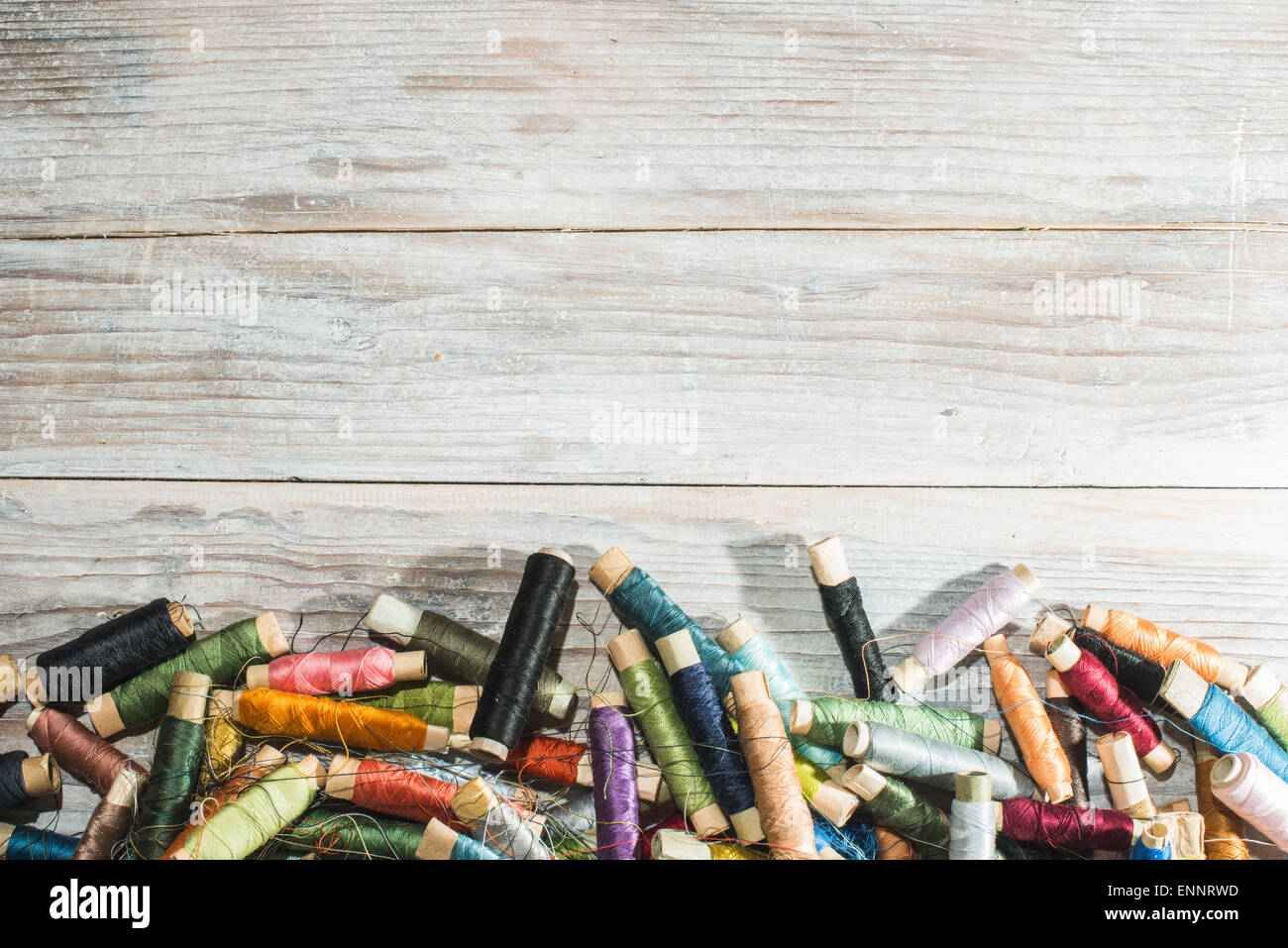 Spools of thread on white wood background Stock Photo - Alamy