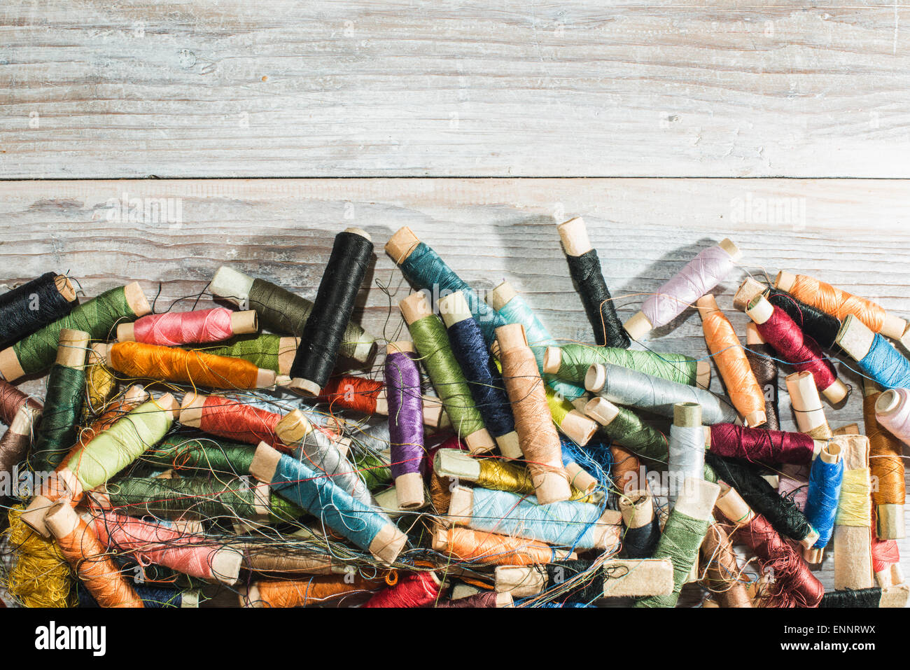 Spools of thread on white wood background Stock Photo - Alamy
