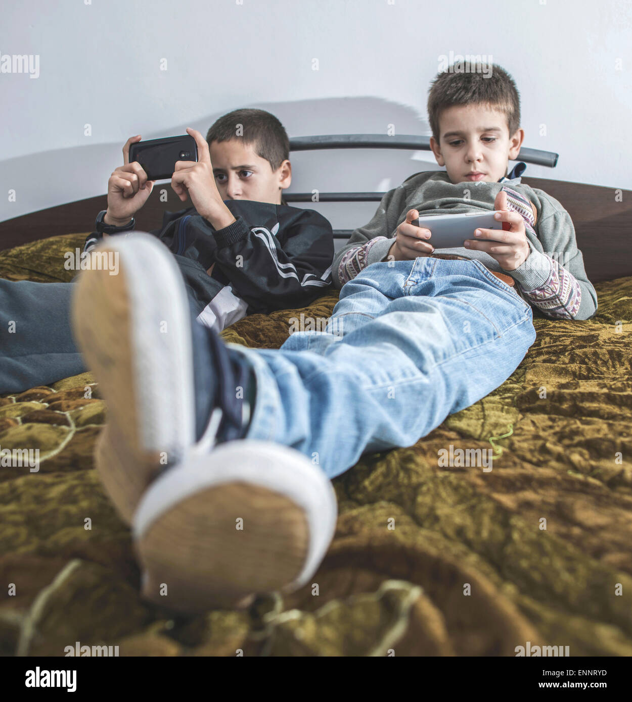 Children playing with their smartphones. Two boys with mobile phones ...