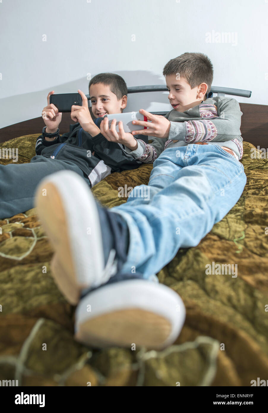 Children playing with their smartphones. Two boys with mobile phones ...