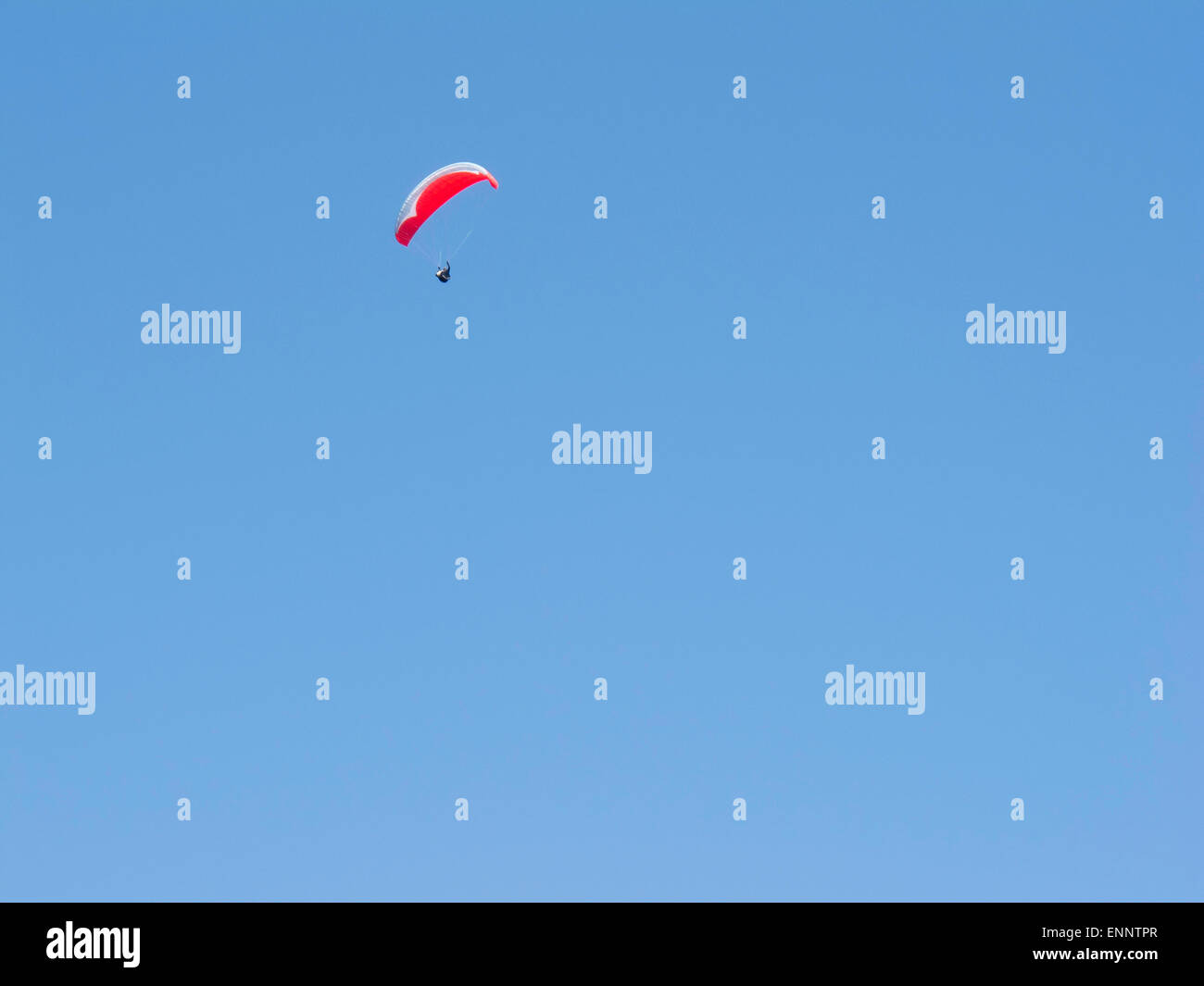 Hang glider with a red canopy against a clear blue sky Stock Photo - Alamy