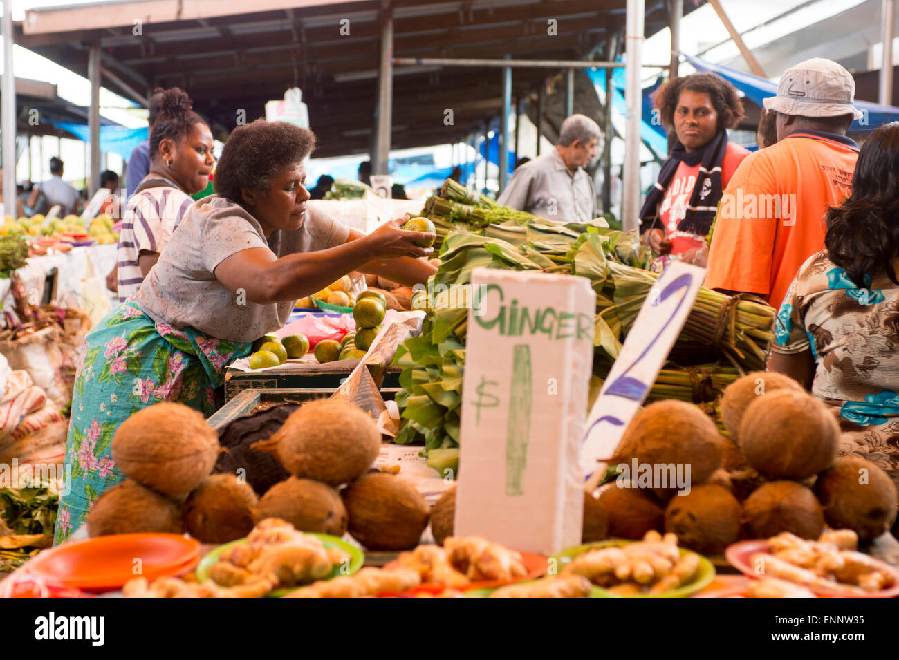 A stall owner sells oranges to a customer. Suva fruit and vegetable ...
