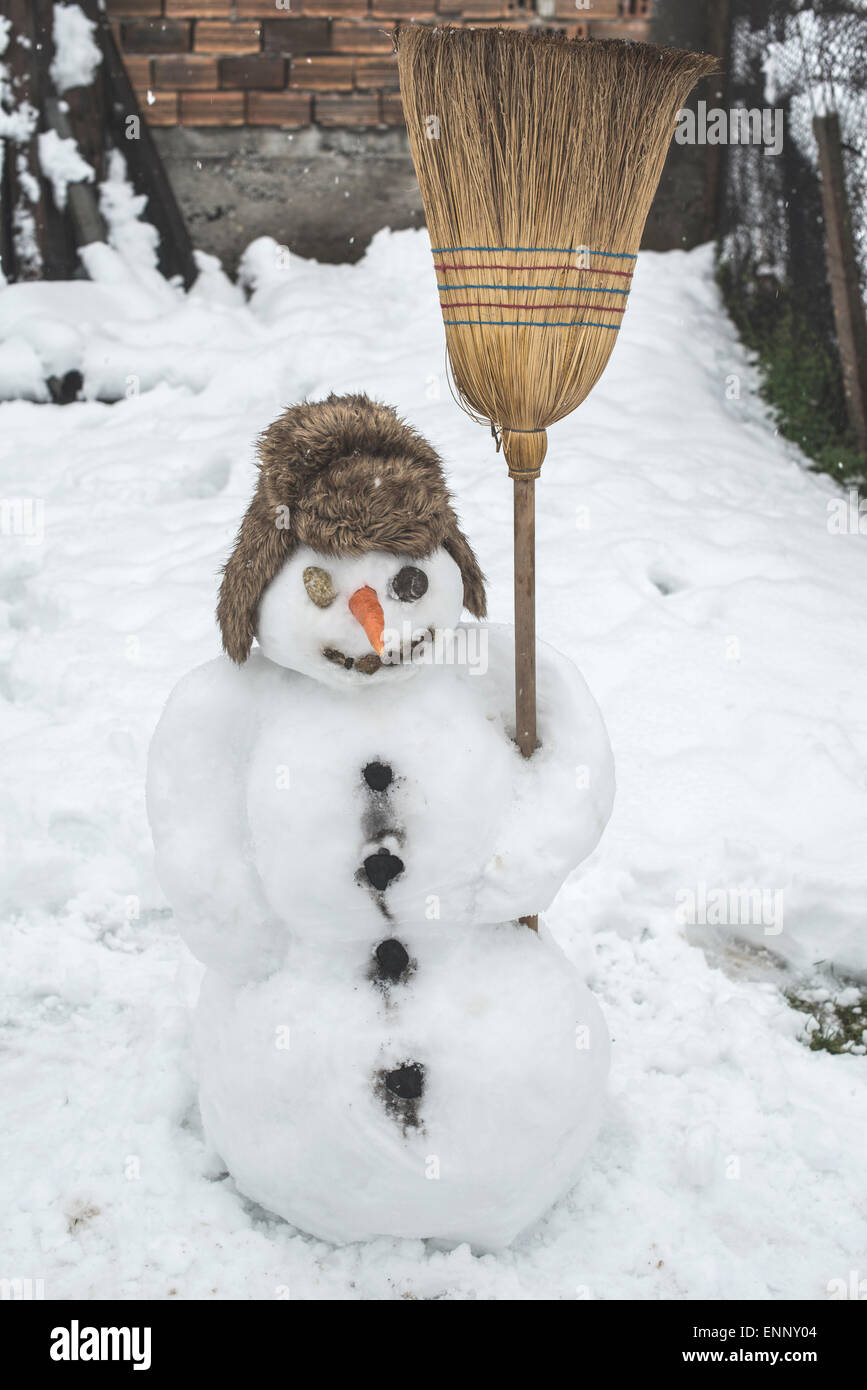 Snowman in the yard holding a broom Stock Photo - Alamy