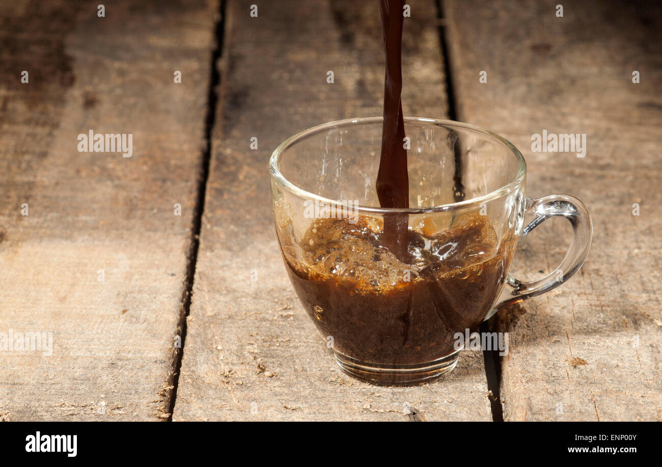 Coffee pouring in glass cup on old wooden background Stock Photo - Alamy
