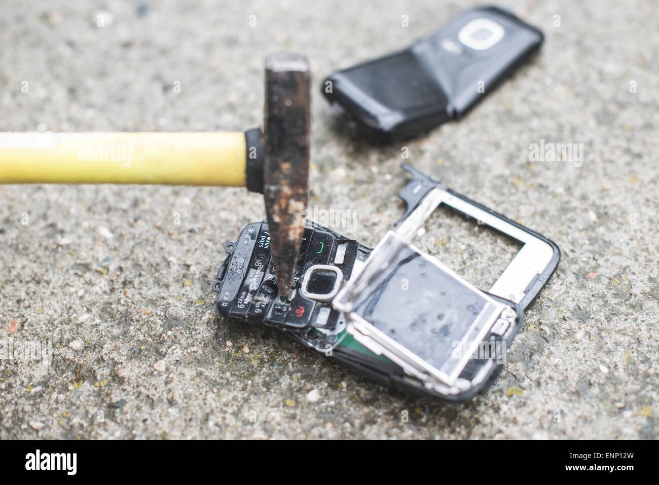 Old broken mobile phone. Hammer crease phone Stock Photo - Alamy