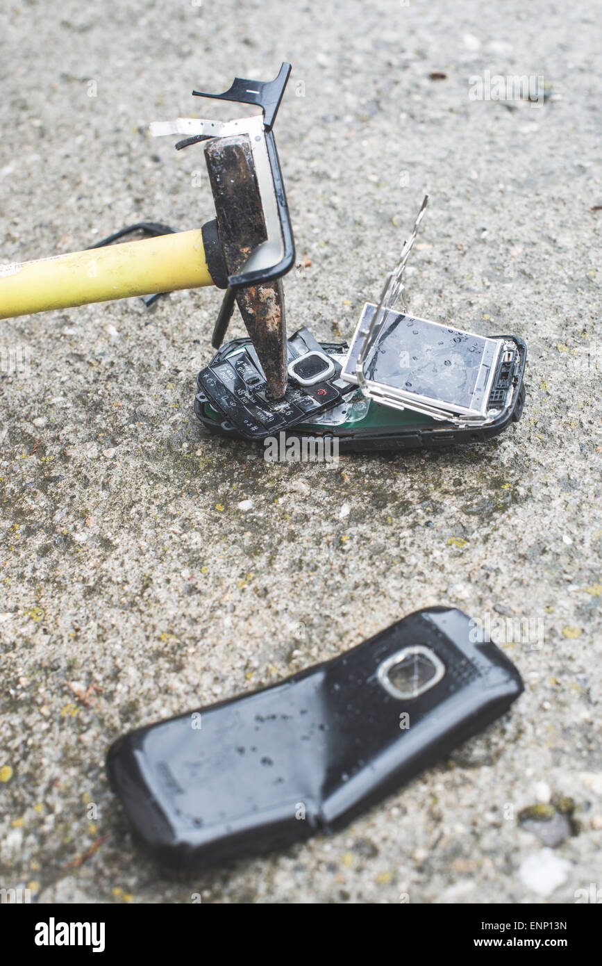 Old broken mobile phone. Hammer crease phone Stock Photo - Alamy