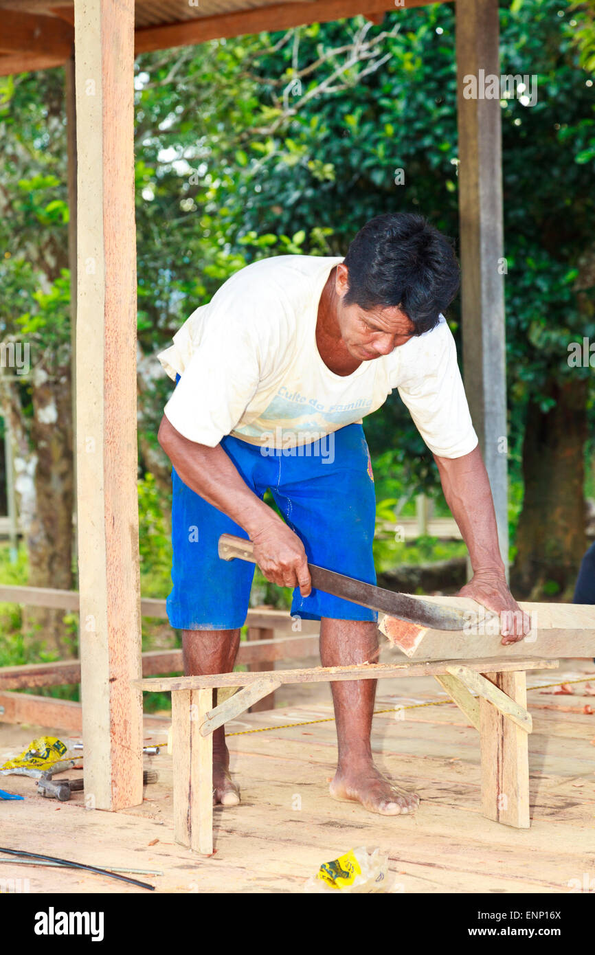 A native Satere man uses the ubiquitous machete to build a new hut in ...