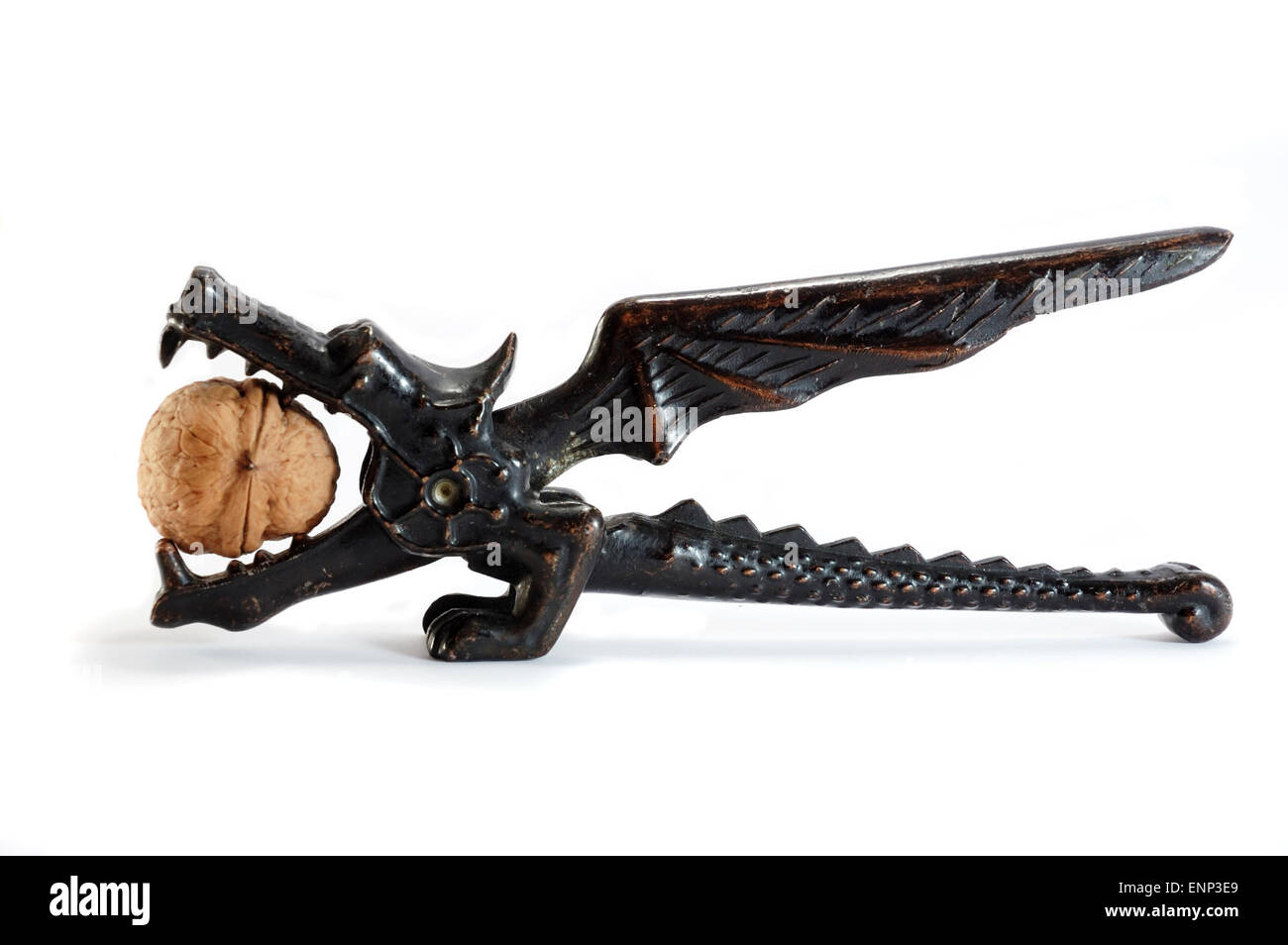 Old dragon shaped nutcracker with nut on white background Stock Photo ...