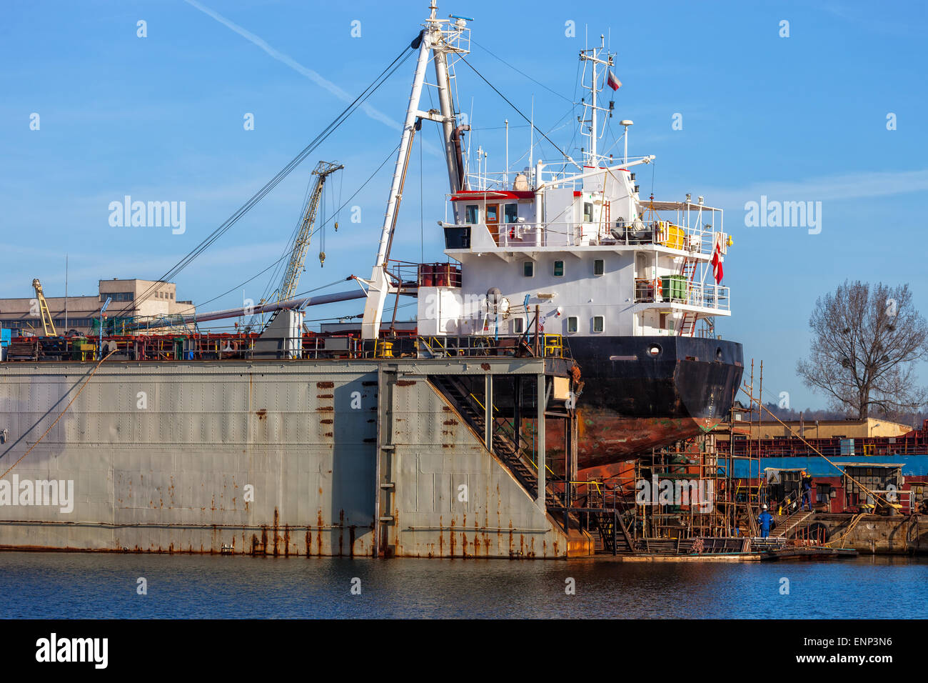 A view of a large ship under repair in dry dock at a shipyard Stock ...