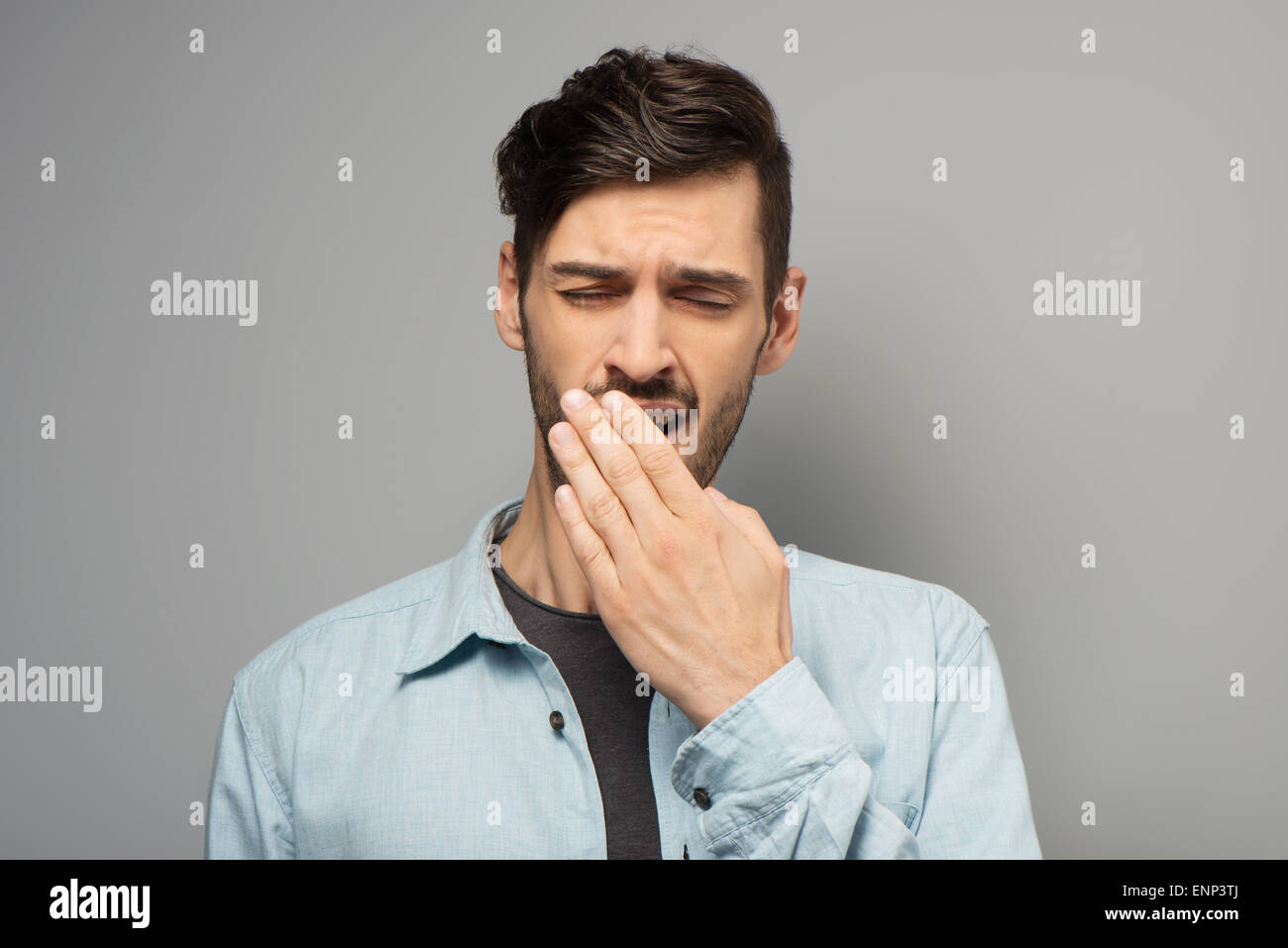Young casual man yawning Stock Photo - Alamy