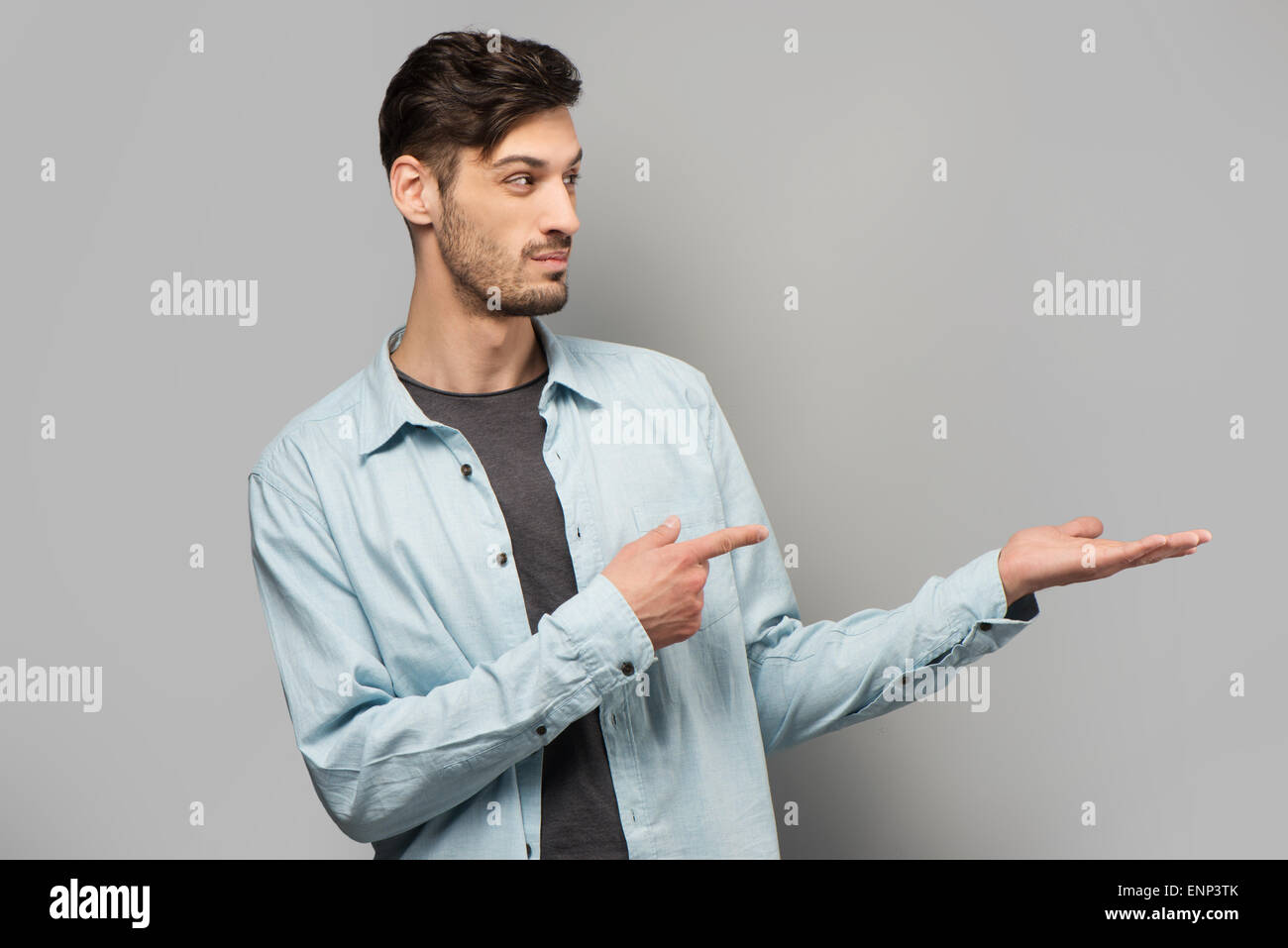Handsome young man pointing at something Stock Photo - Alamy