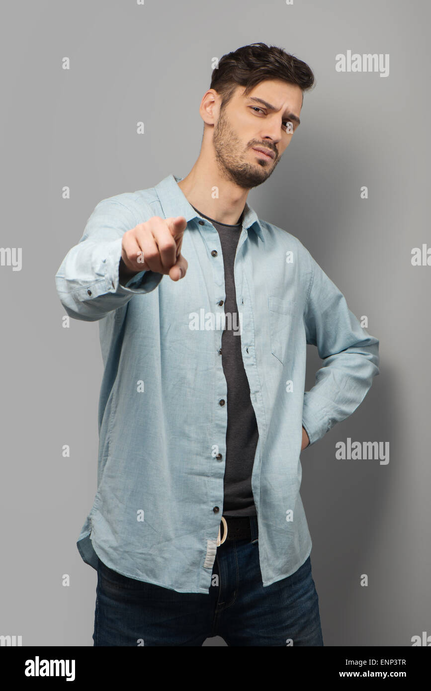 Thoughtful young man pointing at camera Stock Photo - Alamy