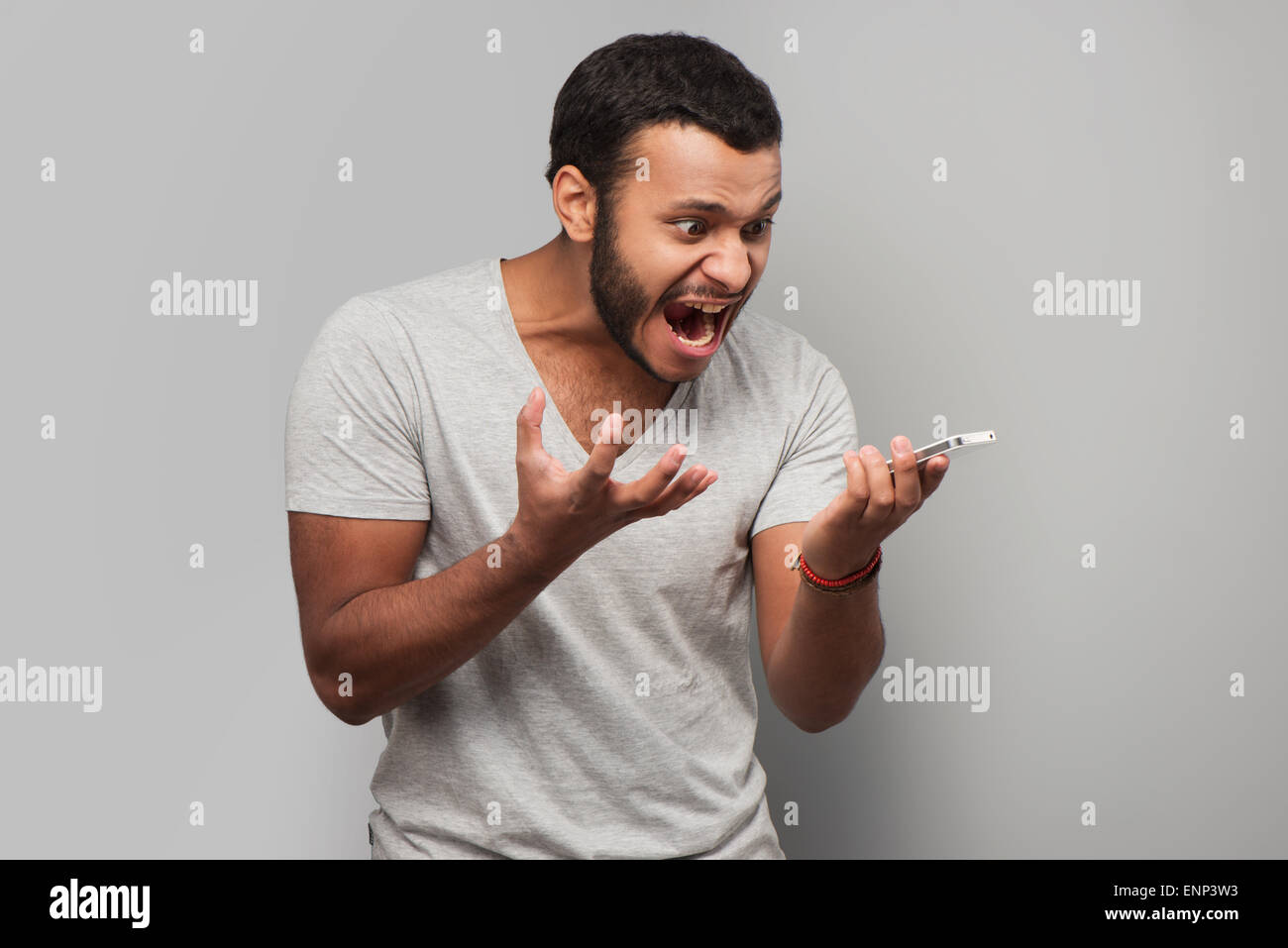 Angry mixed race man screaming at phone Stock Photo - Alamy
