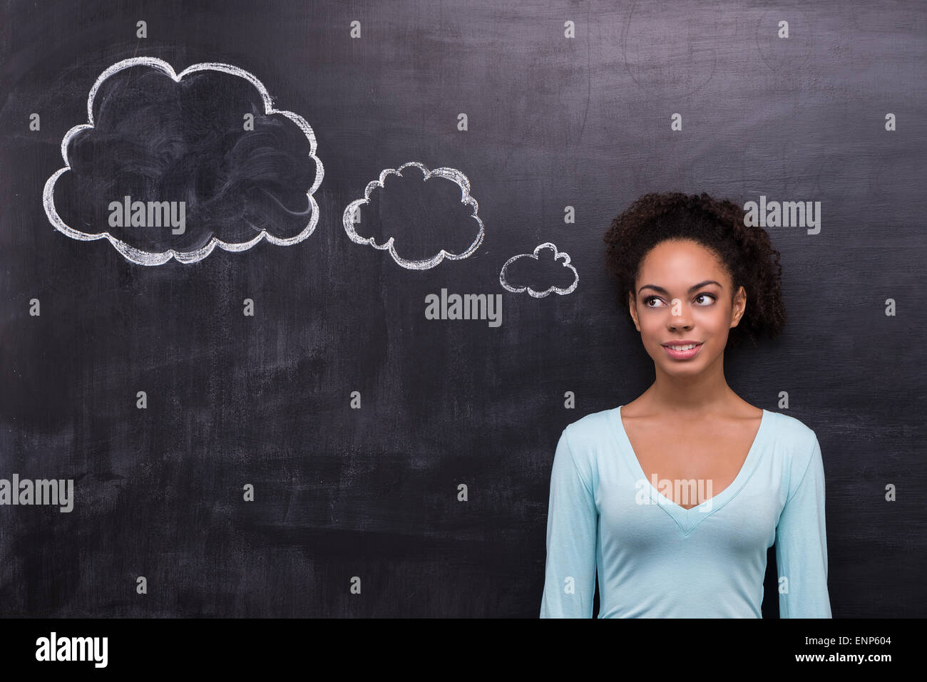 Smiling afro-american woman with cloud formed dialog on chalkboard ...