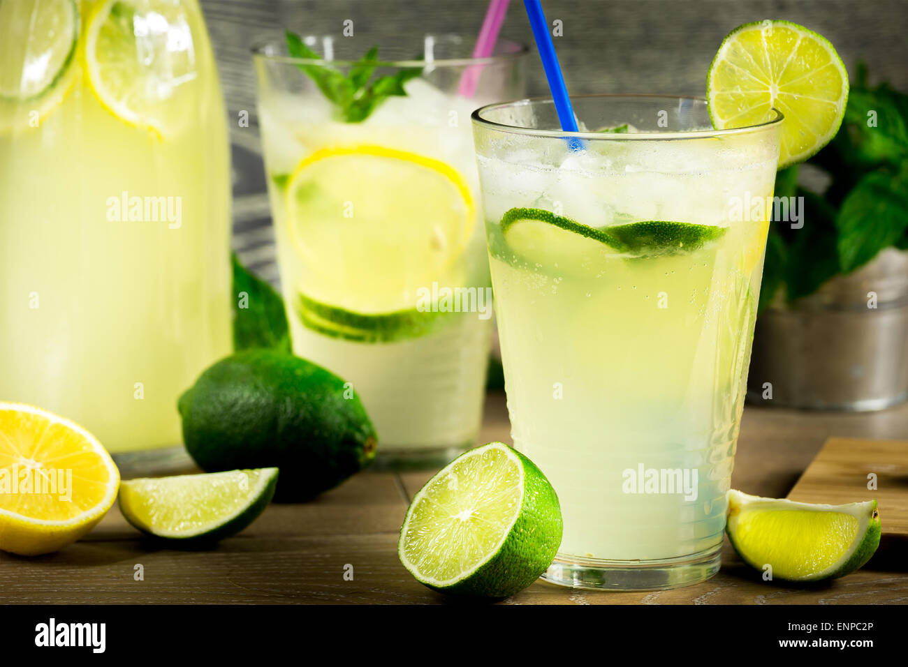 Refreshing lemonade drink and ripe fruits against wooden background ...