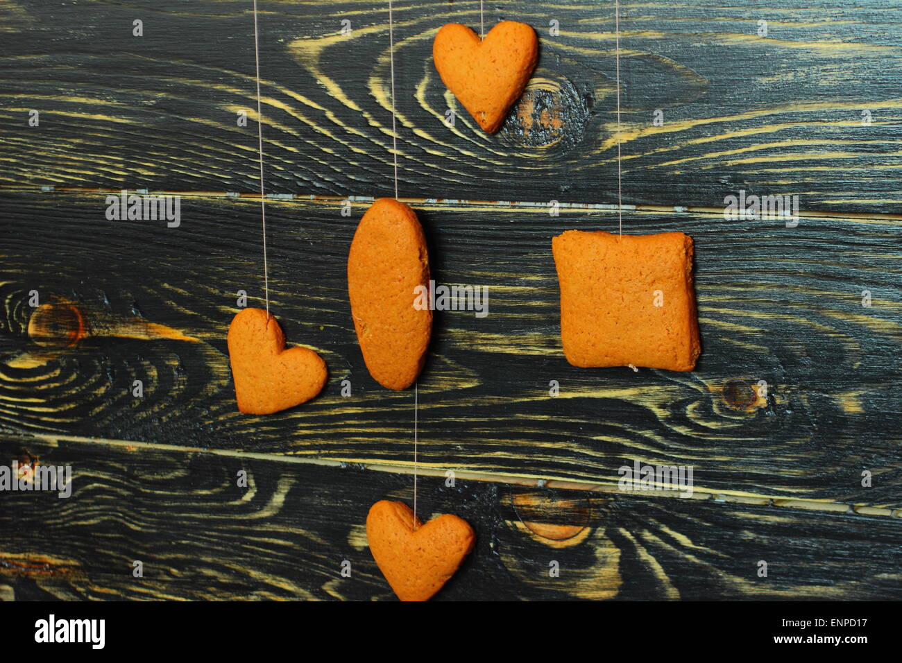cookies of different shapes hanging on a wooden board on strings Stock ...