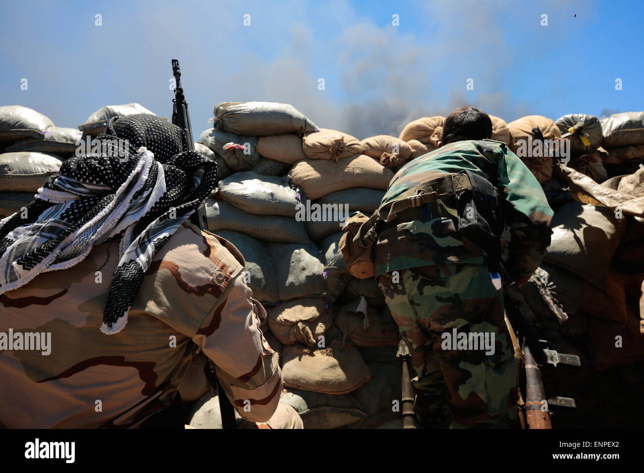 Shingal, Iraq. 7th May, 2015. Kurdish fighters peek over their defenses ...