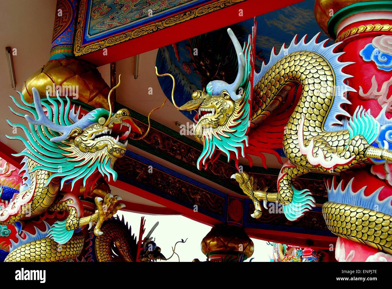Bang Saen, Thailand Gilded dragons face one another from red support ...