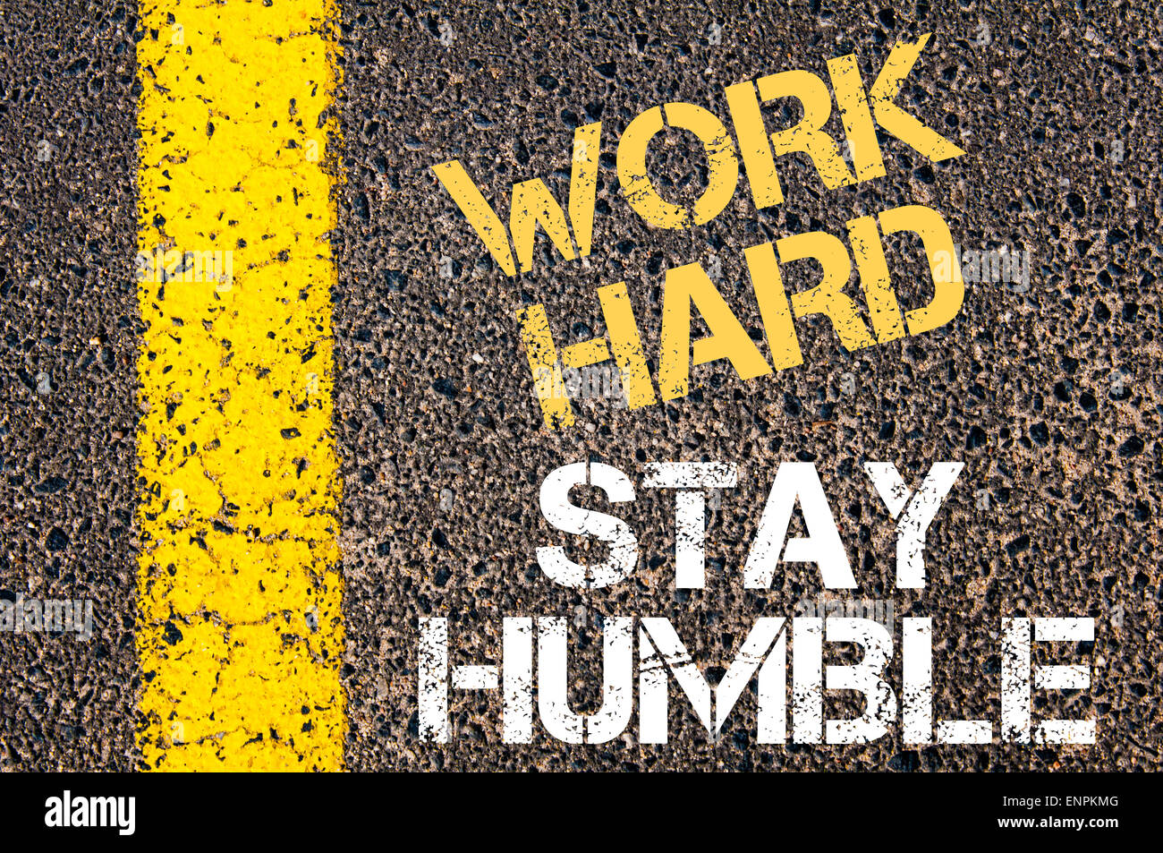 WORK HARD STAY HUMBLE motivational quote. Yellow paint line on the road ...