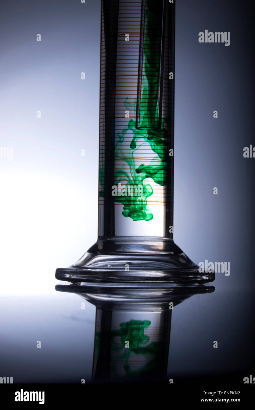 Graduated cylinder with green chemical smoke hi-res stock photography ...