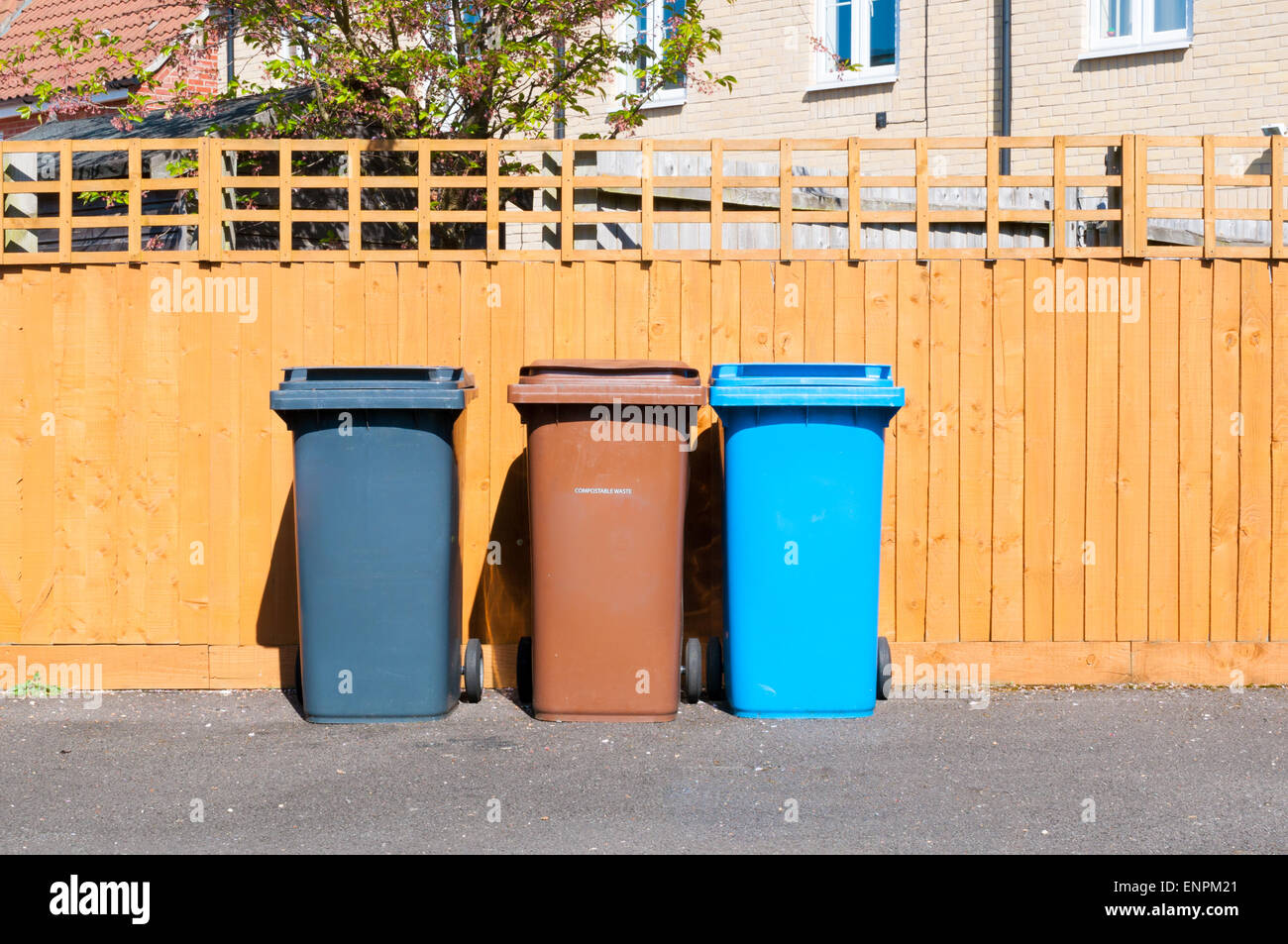 Three plastic waste bins outside a house along the fence Stock Photo ...