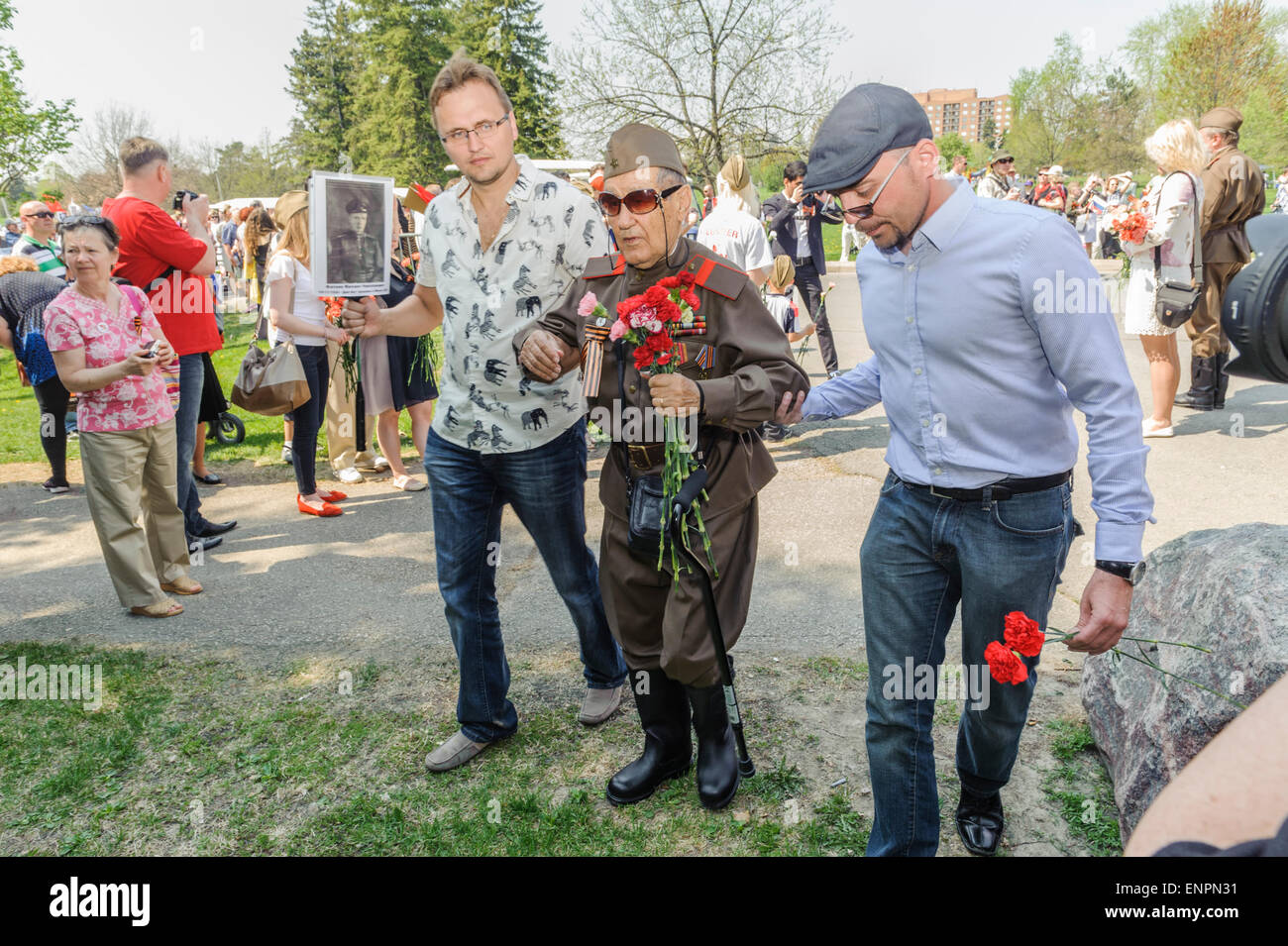 Toronto, Canada. 9th May 2015. Two men help war veteran to walk during ...