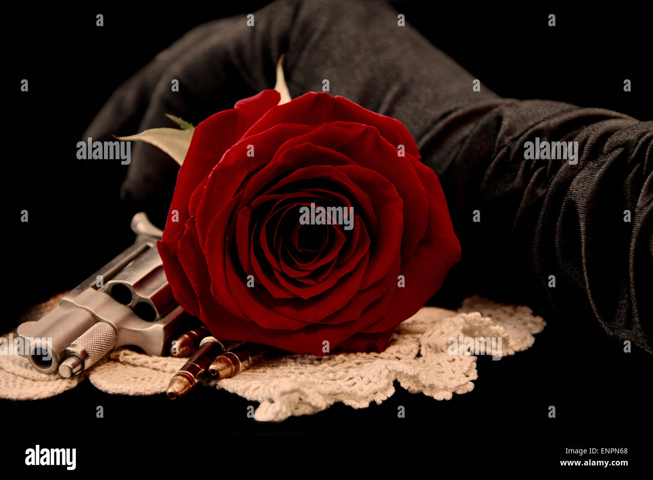 Red Rose with handgun, bullets and hand in black glove on black ...