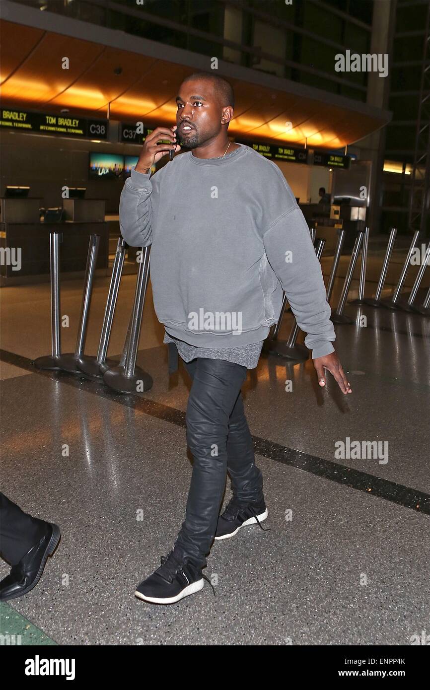 Kanye West talks on his cell phone as he departs from Los Angeles ...