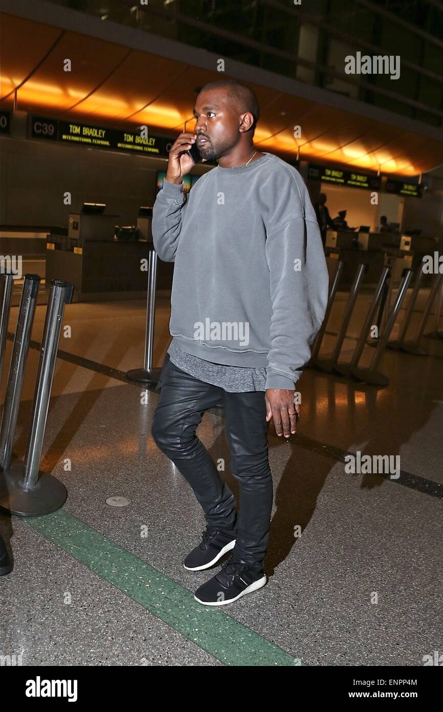 Kanye West talks on his cell phone as he departs from Los Angeles ...