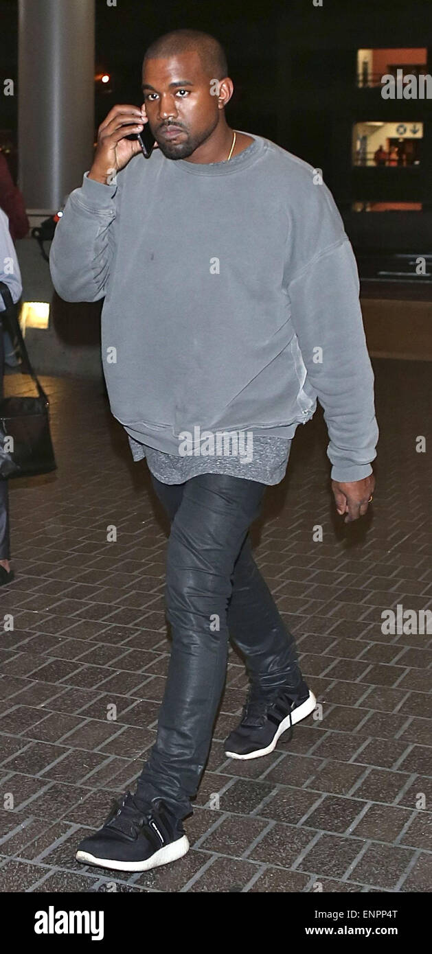 Kanye West talks on his cell phone as he departs from Los Angeles ...