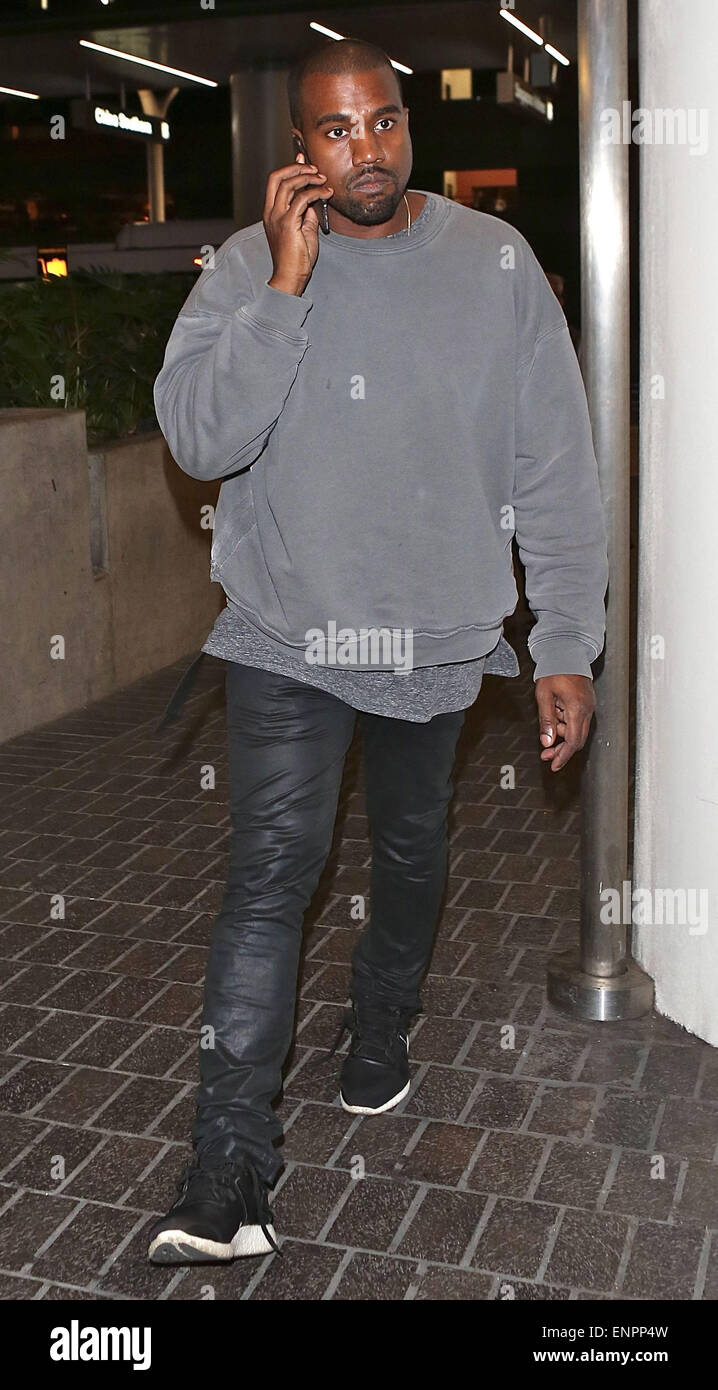 Kanye West talks on his cell phone as he departs from Los Angeles ...