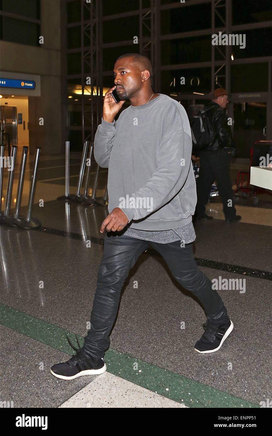 Kanye West talks on his cell phone as he departs from Los Angeles ...