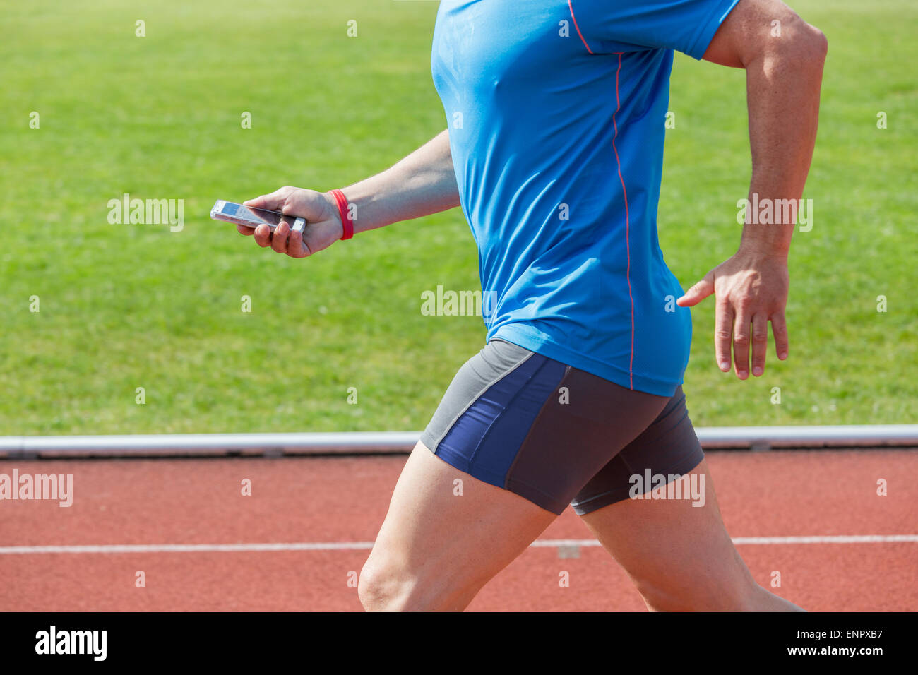 Runner checks his fitness data on a smart phone while running before ...