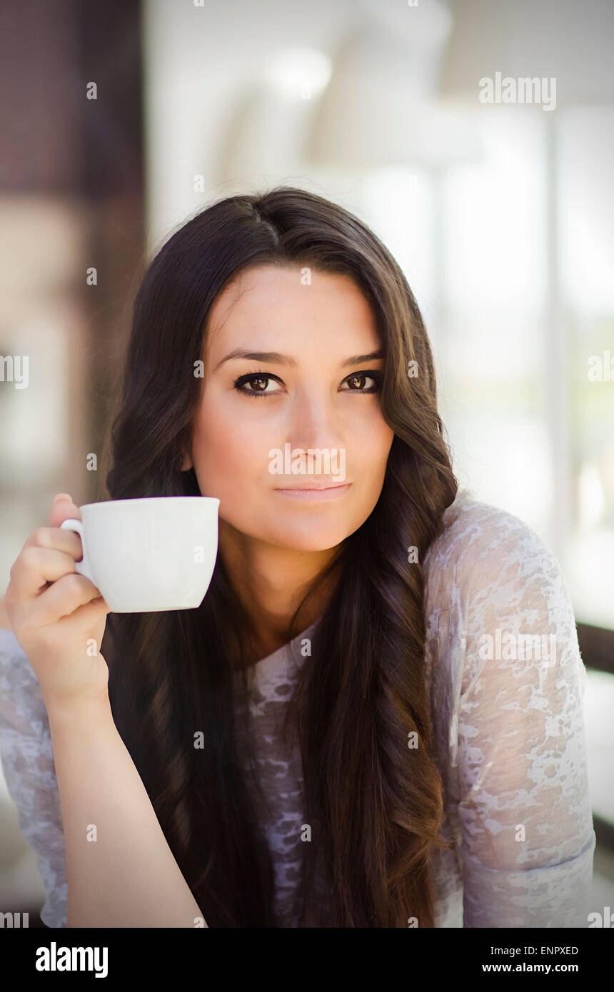 Young woman drinking coffee in the cafe Stock Photo - Alamy