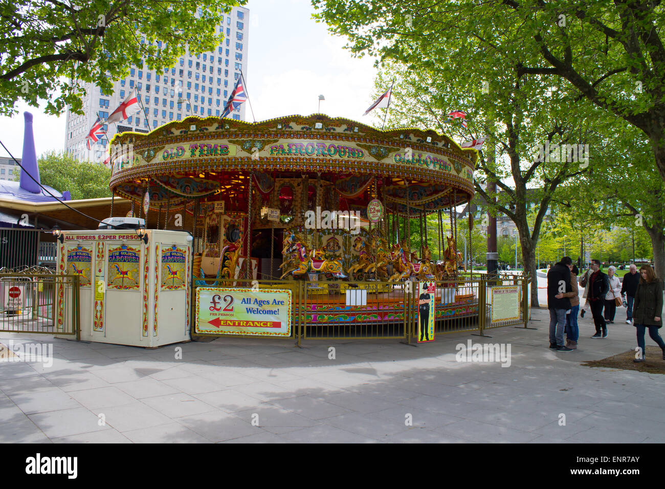 People walking past a colorful carousel in central London, United ...