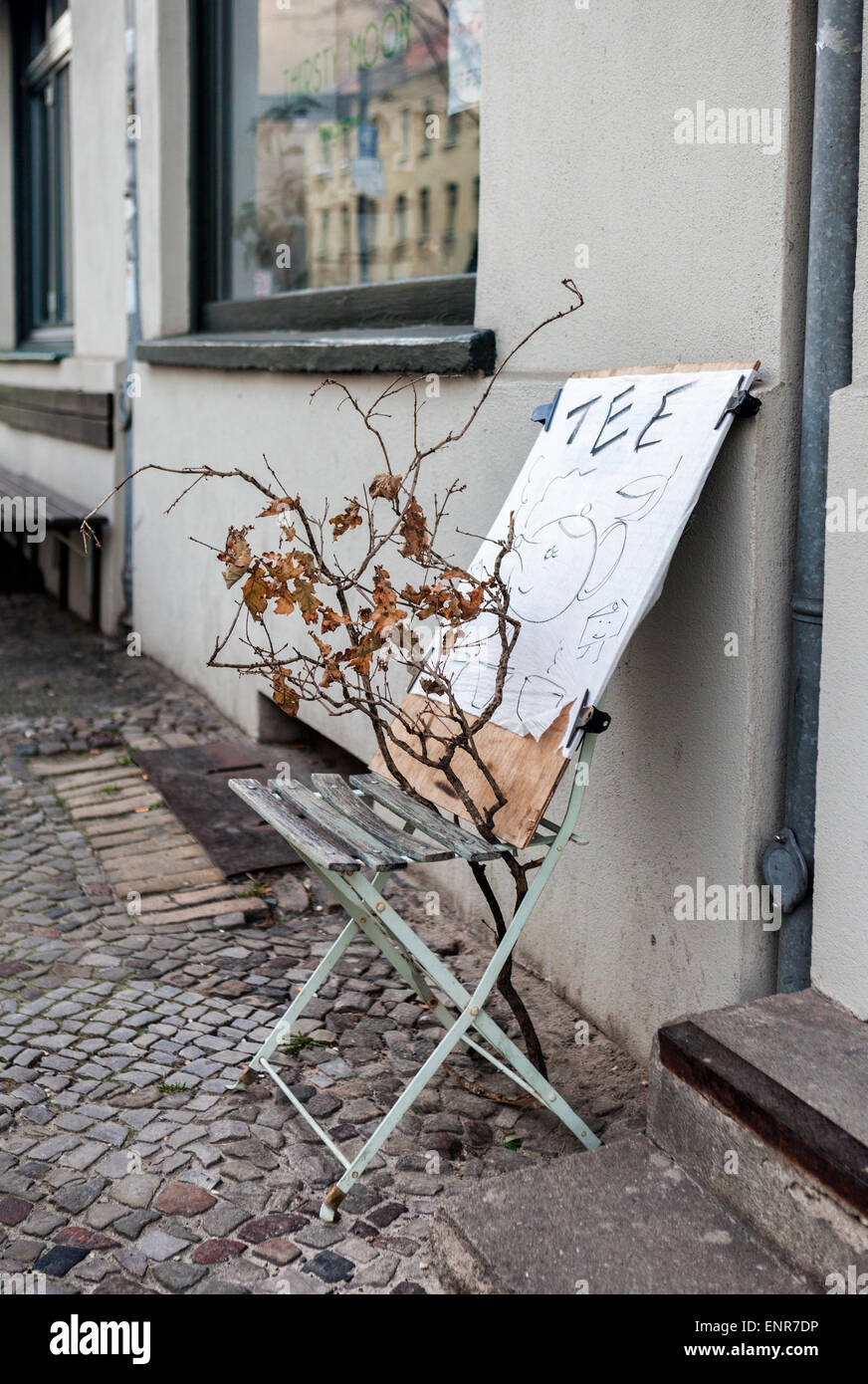 Tea shop exterior with lone chair, sign and dead tree branch Stock ...