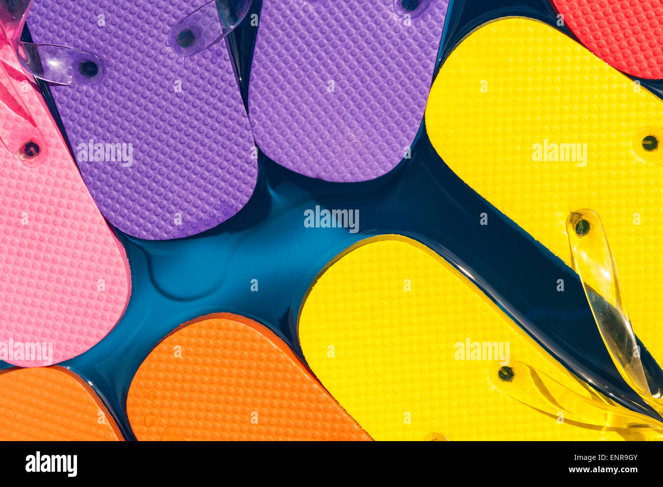 Multicolored flip flops floating in small pool Stock Photo - Alamy