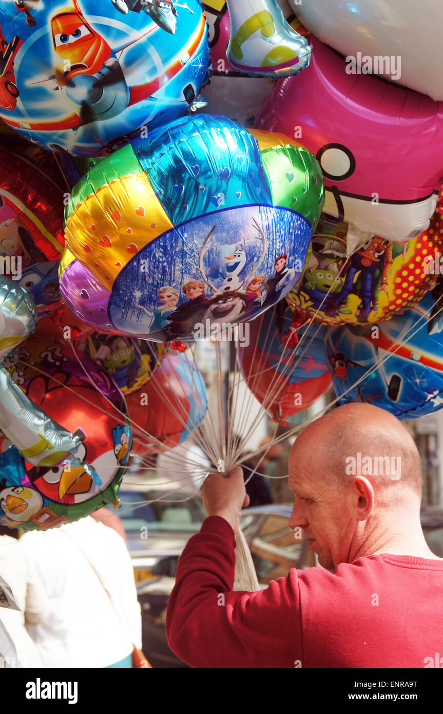 Balloon seller holding colorful balloons Stock Photo - Alamy