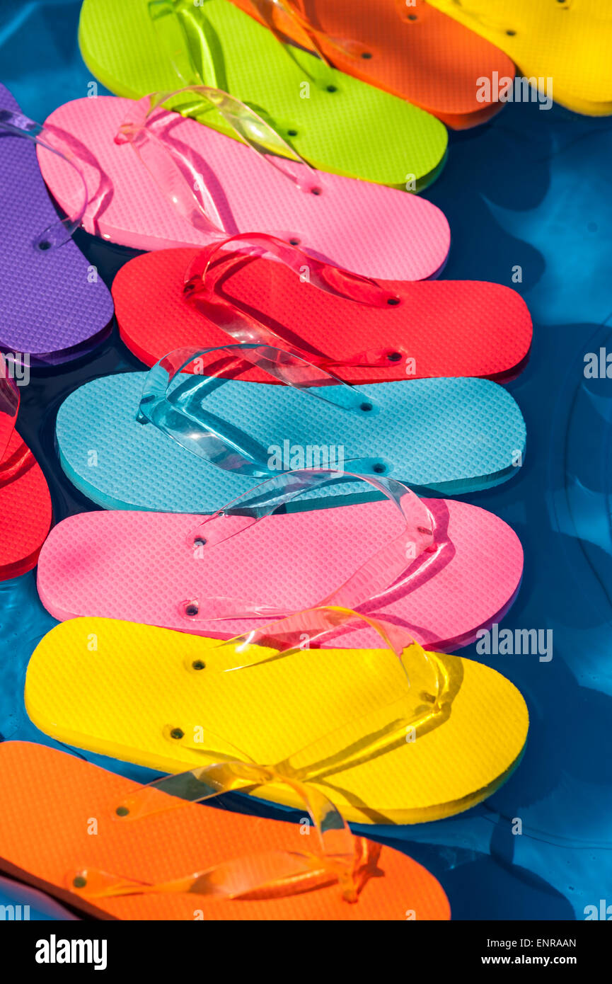 Multicolored flip flops floating in small pool Stock Photo - Alamy
