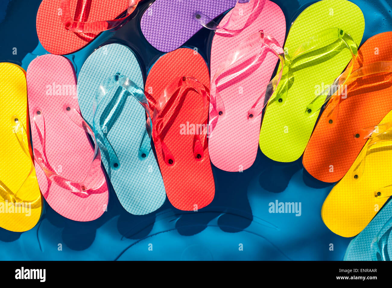 Multicolored flip flops floating in small pool Stock Photo - Alamy