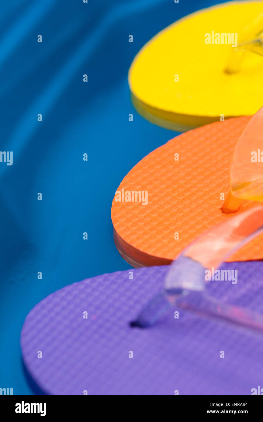 Multicolored flip flops floating in small pool Stock Photo - Alamy