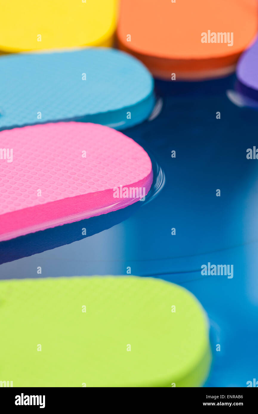 Multicolored flip flops floating in small pool Stock Photo - Alamy