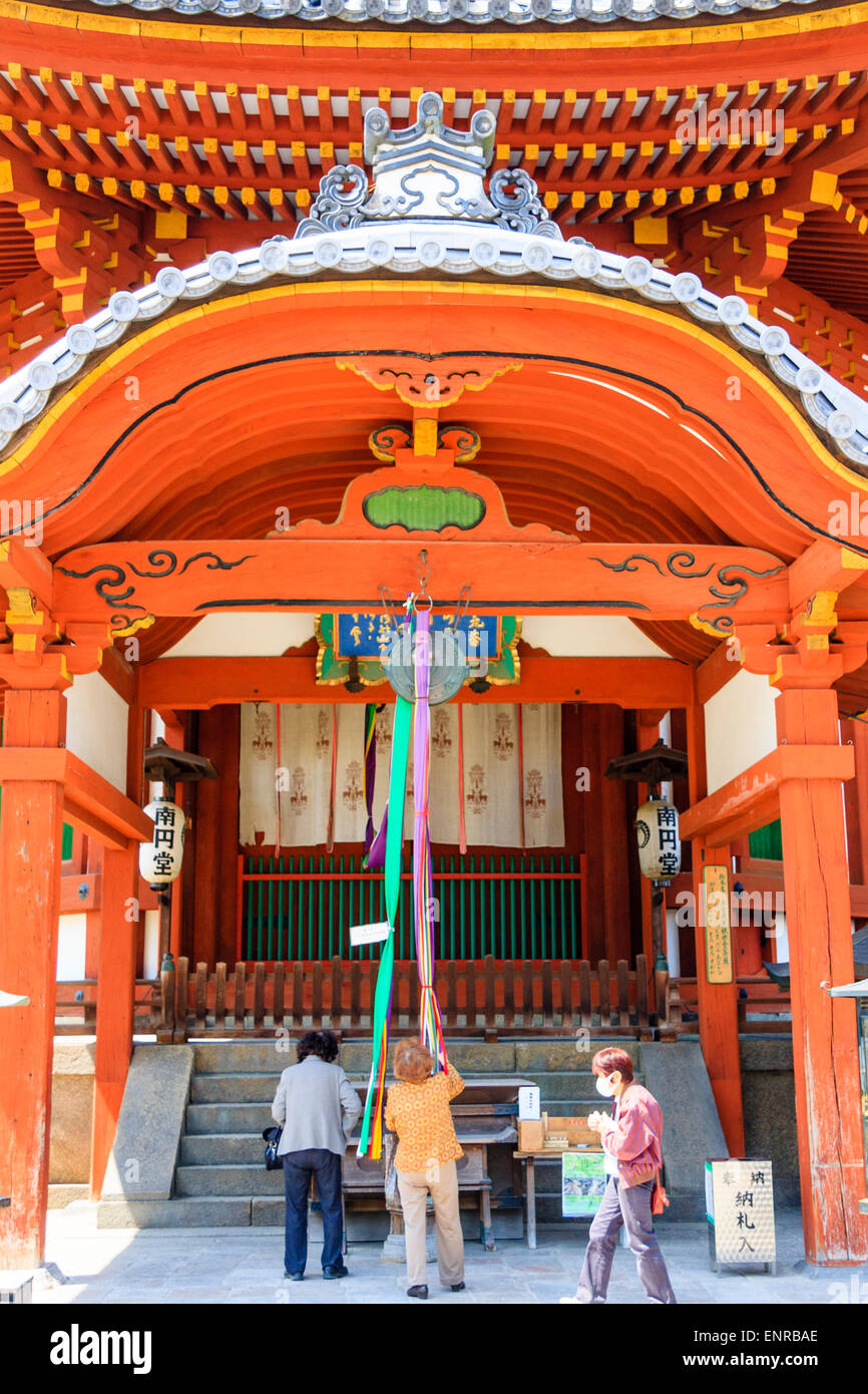 Worshippers ringing the bell while standing in front of the main ...