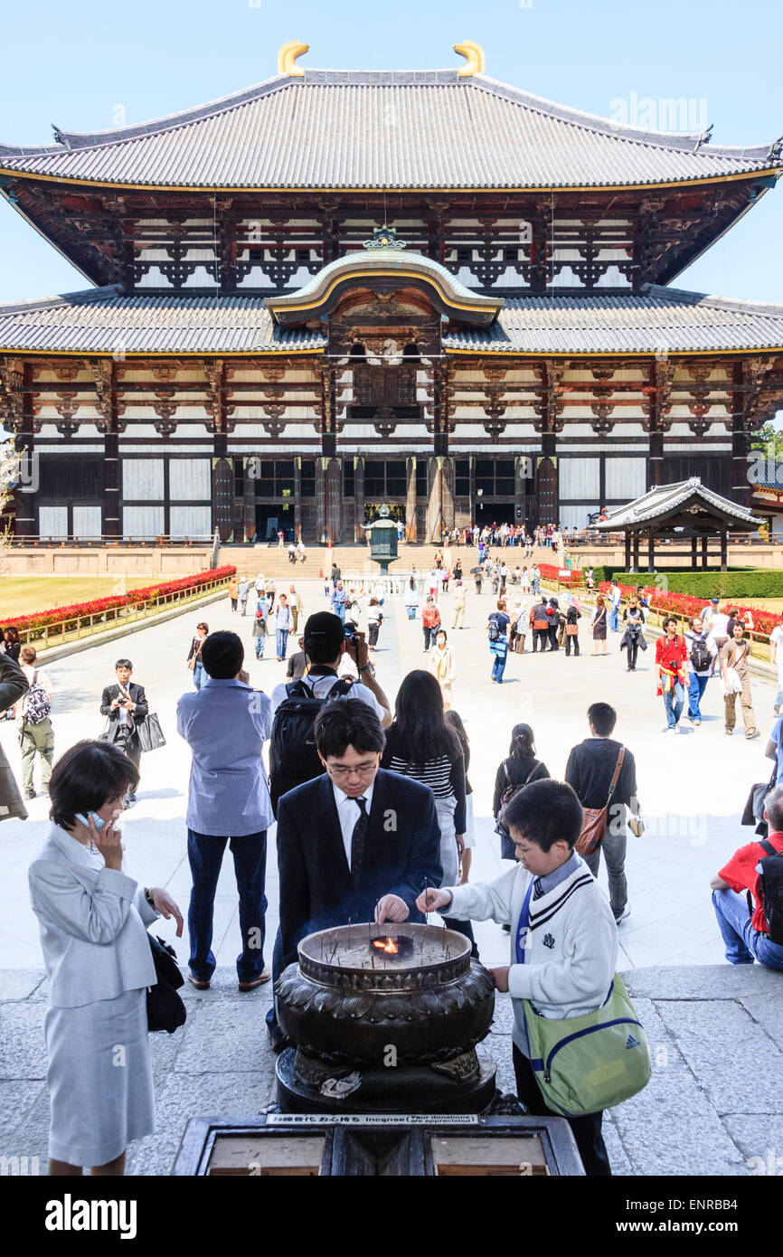 The Todai-ji temple at Nara, Japan. In foreground an Asian family lit ...