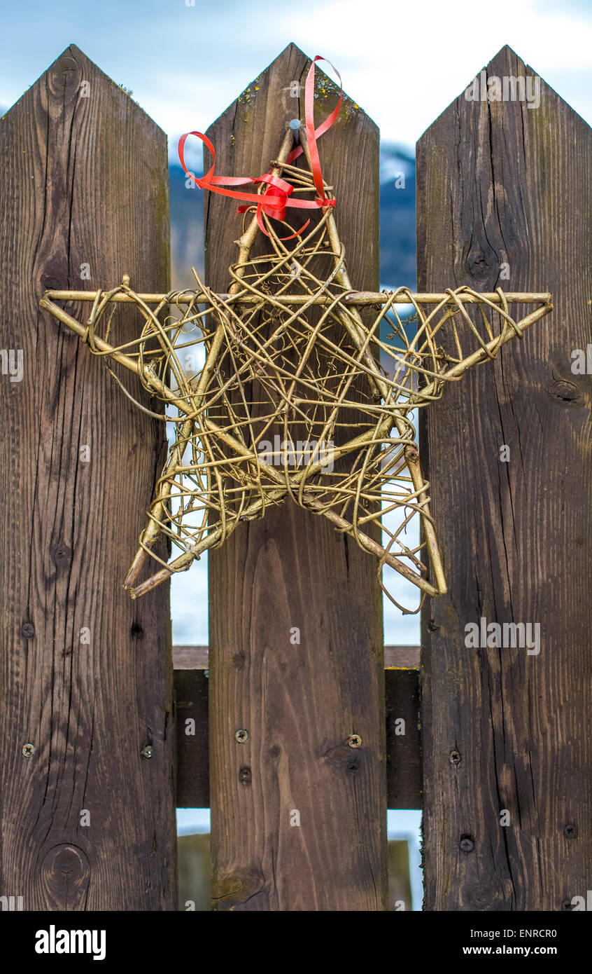 Closeup photo of decorative Christmas star hanging on wooden fence ...