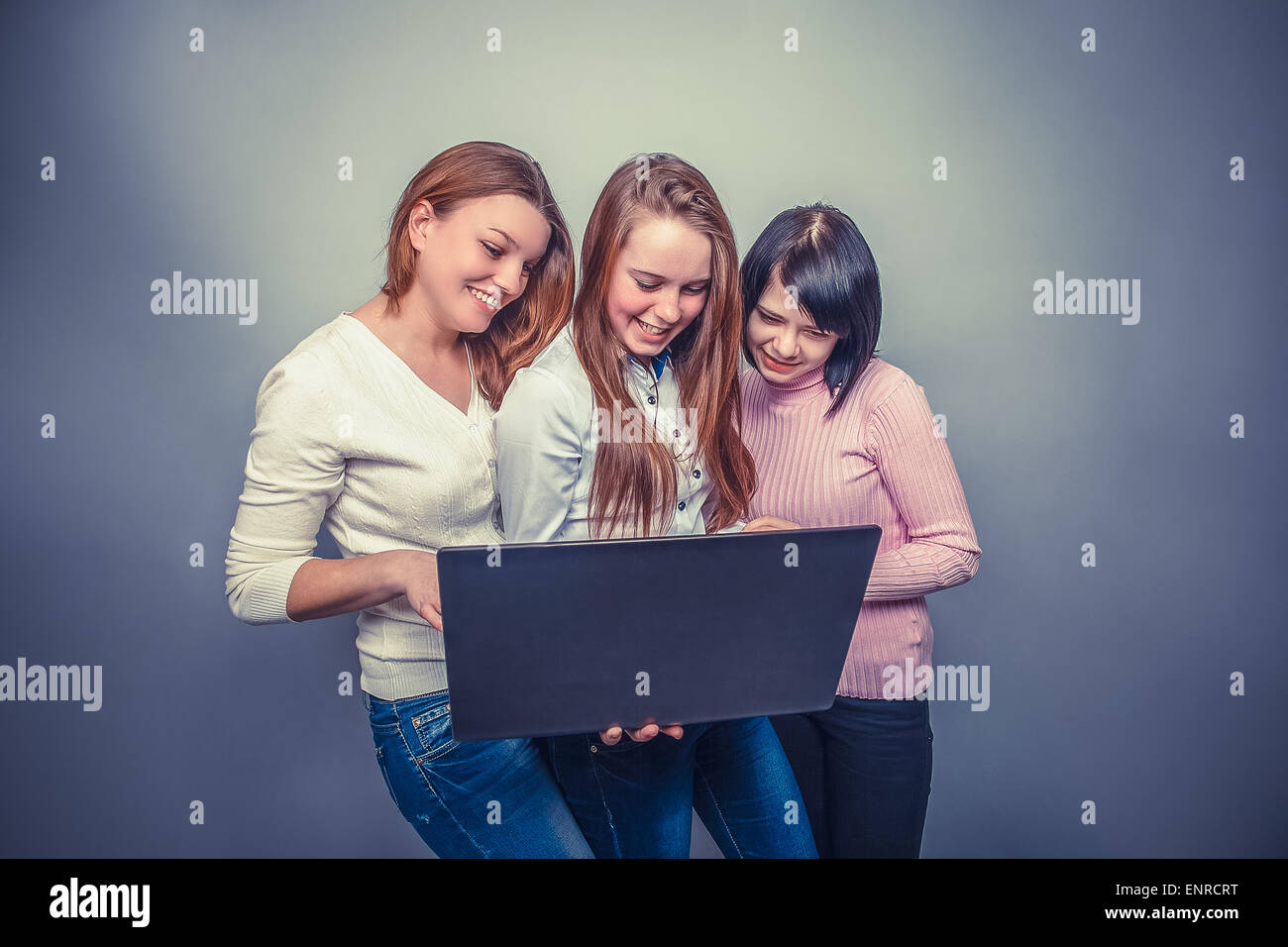 Three girls European appearance girlfriend looking at computer screen ...