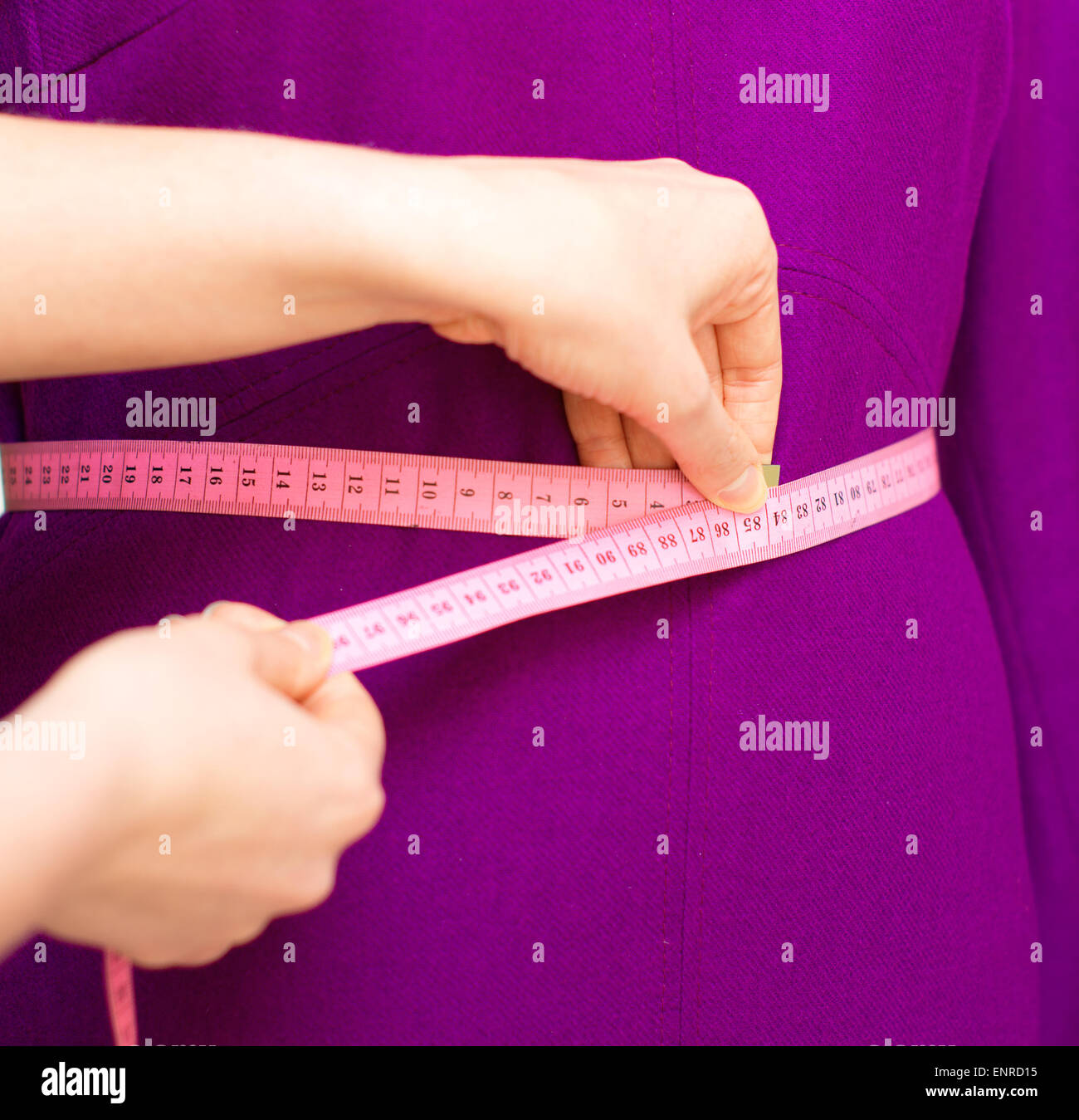 Fashion designer with measuring tape working on mannequin Stock Photo ...