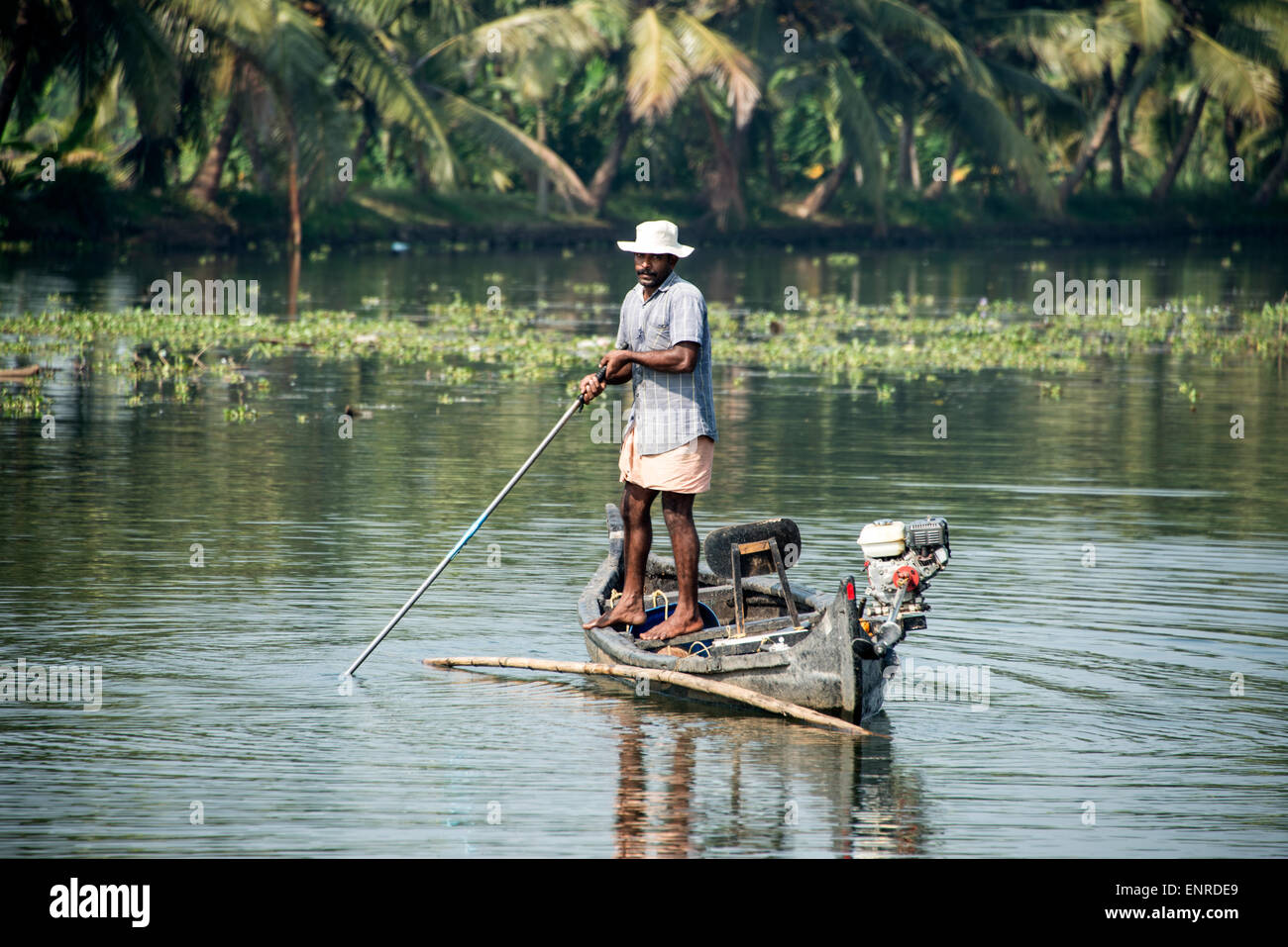 A villager using his pole on his boat without the use of his outboard ...