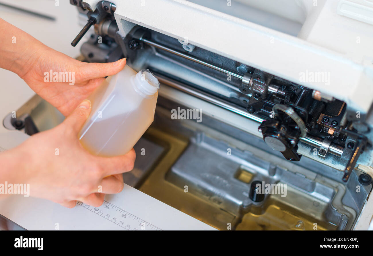 Female hand adding oil in sewing machine. Maintenance Stock Photo - Alamy