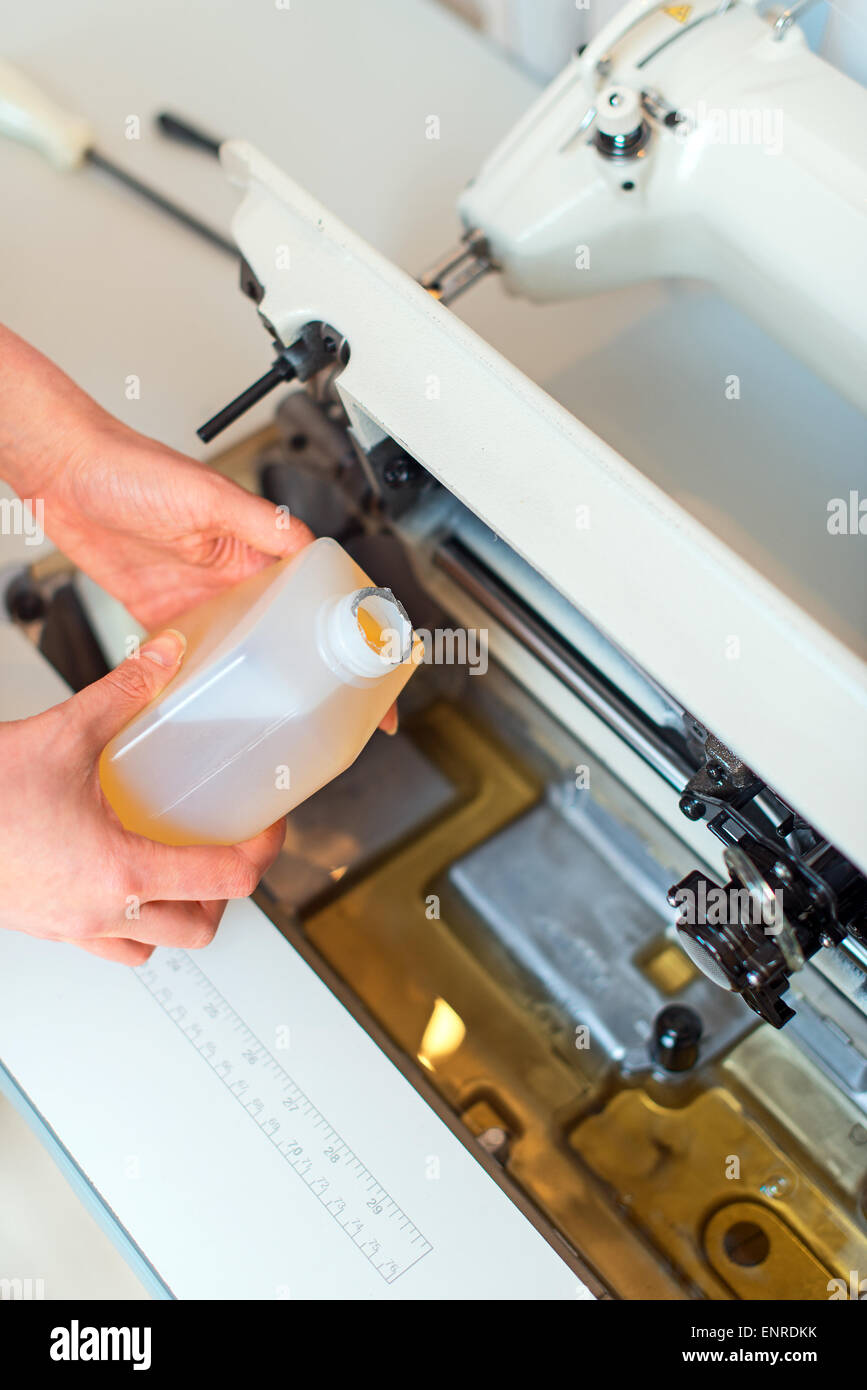 Female hand adding oil in sewing machine. Maintenance Stock Photo - Alamy
